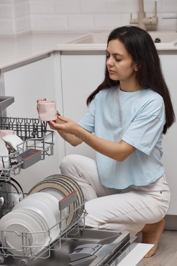 Pretty Woman Unloading from Open Dishwasher Machine with Clean Utensils ...