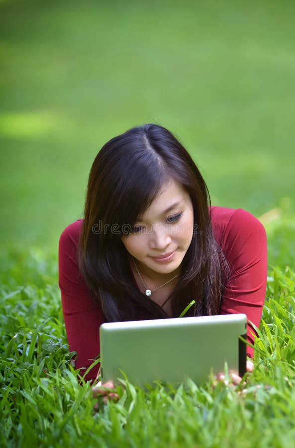 Pretty woman using tablet stock photo. Image of grass - 27473802