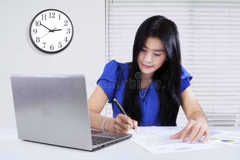Pretty Woman Writing on Document in Office Stock Image - Image of graph ...