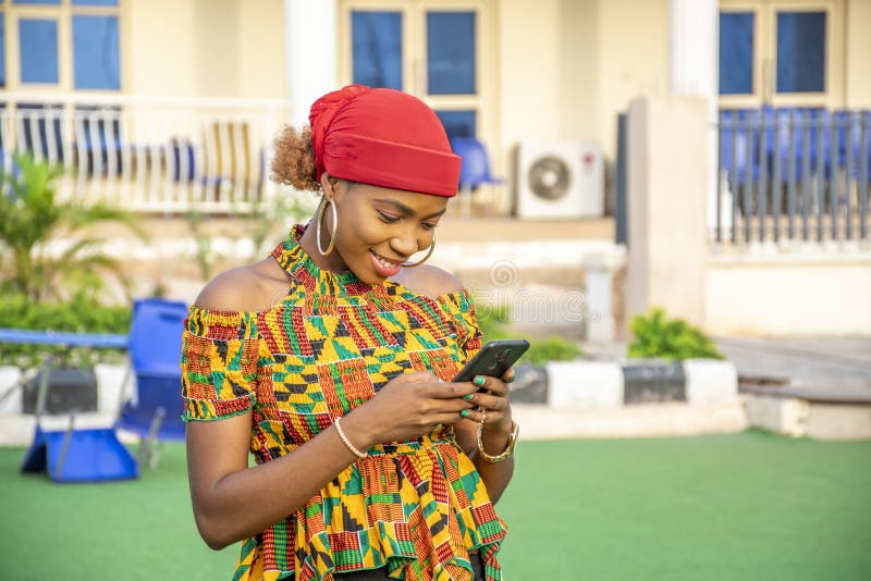 Pretty Young African Woman Smiling and Using Her Mobile Phone Outdoors ...