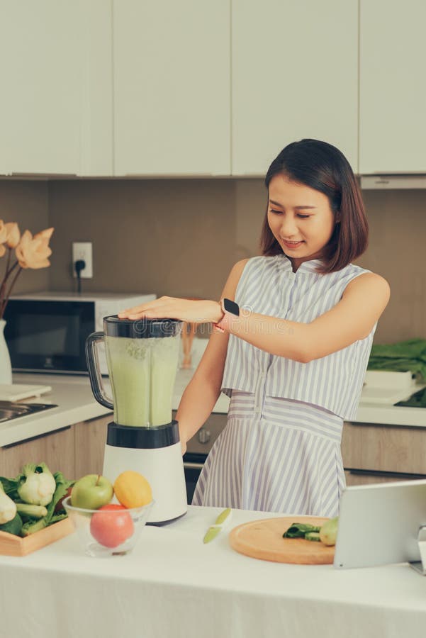 Pretty Young Asian Woman Making Smoothie in Blender in the Kitchen ...