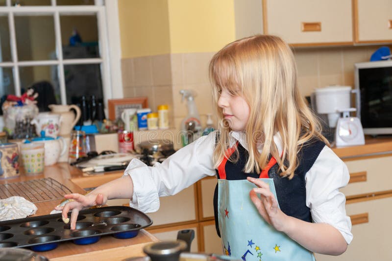 A Pretty Young Blonde Girl Baking in a Messy Kitchen Stock Image ...