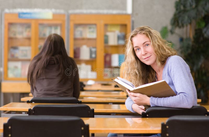 Pretty Young College Student in a Library. Looking at Camera Stock ...