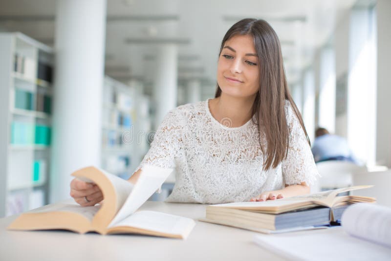 Pretty, Young College Student Looking for a Book in the Library Stock ...