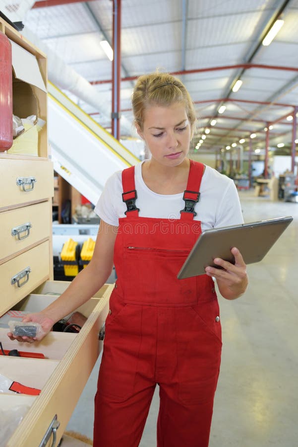 Pretty Young Engineer Looking at Digital Tablet in Warehouse Stock ...