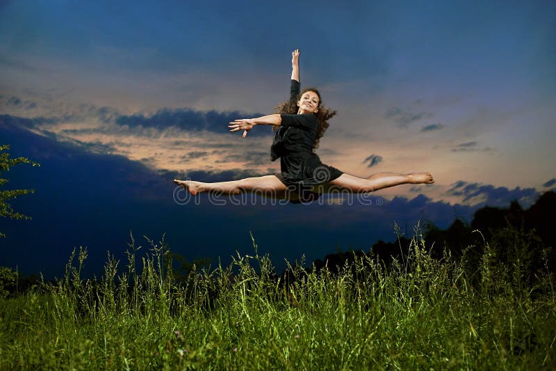 Smiling, Curly Dancer Performs Vertical Side Splits in Grassy Field ...