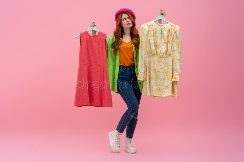 Pretty Young Woman in Bright Clothes Choosing between Two Dresses Stock ...