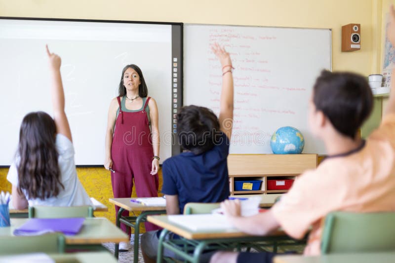 Primary School Teacher Teaching Young Students in Class Stock Photo ...