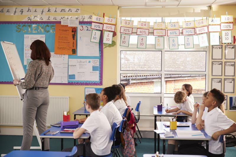 Primary School Teacher Writing on a Flip Chart in a Lesson Stock Photo ...