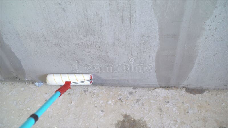 Primer Application by Roller. the House is Under Construction. Worker ...