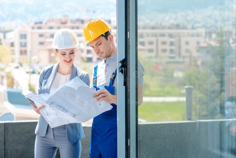 Principal and Builder Reading Blueprints on Construction Site Stock ...