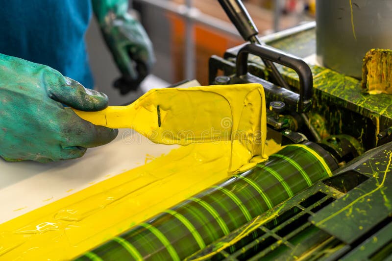 Print Worker Spreading Yellow Ink on Industrial CMYK Printer Machine ...