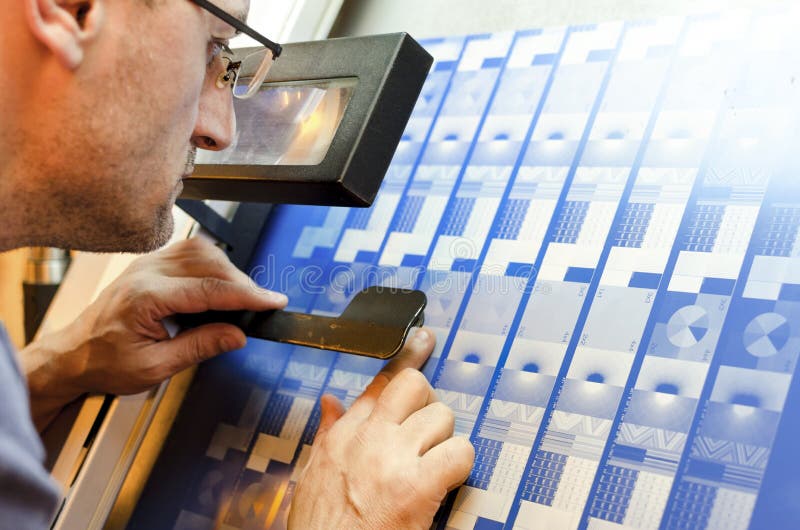 Printer Looking through an Eye Glass To Check the Print Plates ...