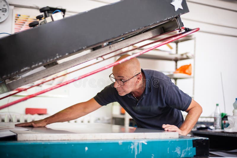 An Experienced Operator Works on a Screen Printing Machine Stock Photo ...