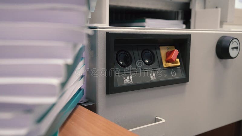 Printing House Worker Operating Cutting Machine. Worker Cutting a Stack ...
