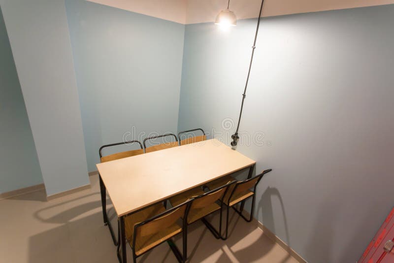 Prison Style Room with Wooden Table and Chairs in a Minimalistic Design ...