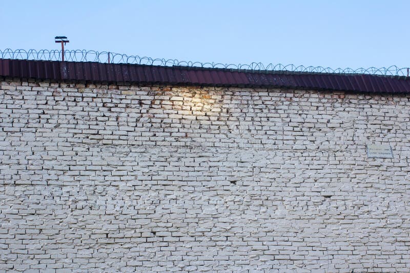 Prison Wall with Barbed Wire. the Texture of a White Brick Wall Stock ...