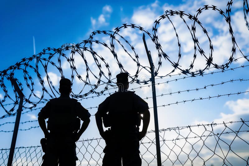 Prison Yard Security: Two Guards Patrolling Inside Razor Wire-enclosed ...