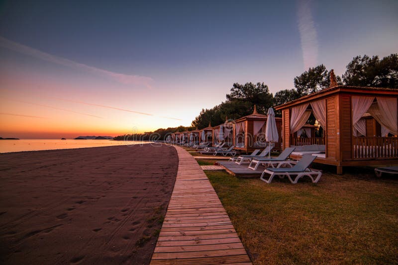 Private Beach Cabanas on a Serene Sandy Shoreline at Sunset Stock Photo ...