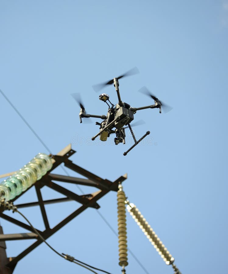 Pro Quadcopter with Camera Aboard Flying in a Sky, Electric Pylon ...