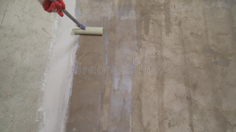 Male Hand Applies Fresh Paint and Primer To the Surface of the Wall ...