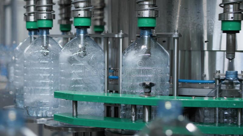 The Process of Automatic Filling of Water into a Plastic Bottle on the ...