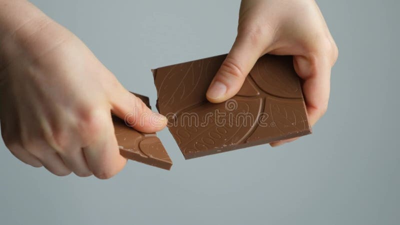 The Process of Breaking a Chocolate Bar into Pieces, Hands Close-up ...