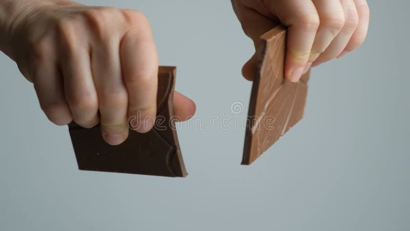 The Process of Breaking a Chocolate Bar into Pieces, Hands Close-up ...