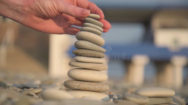 The Process of Building a Pyramid of Stones. a Close-up Hand Places the ...