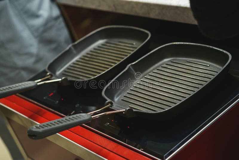 The Process of Cooking in the Kitchen. Special Black Grills on the Hob ...