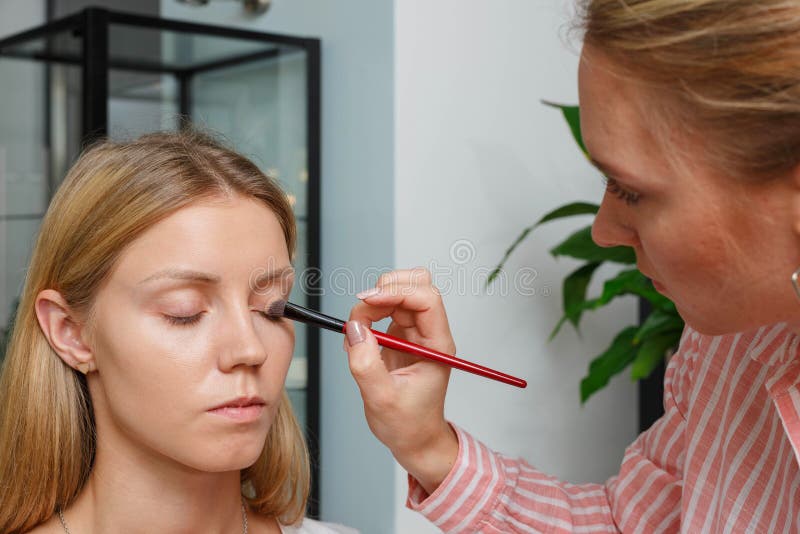 The Process of Creating Makeup. Makeup Artist Working with a Brush on ...