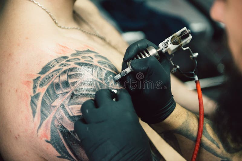 The Process of Creating a Tattoo on the Back of a Man Stock Image ...