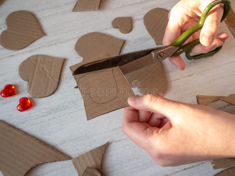 The Process of Cutting Out Hearts with Scissors from Cardboard. the ...