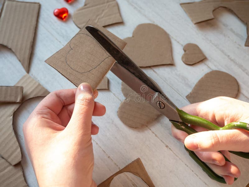 The Process of Cutting Out Hearts with Scissors from Cardboard. the ...