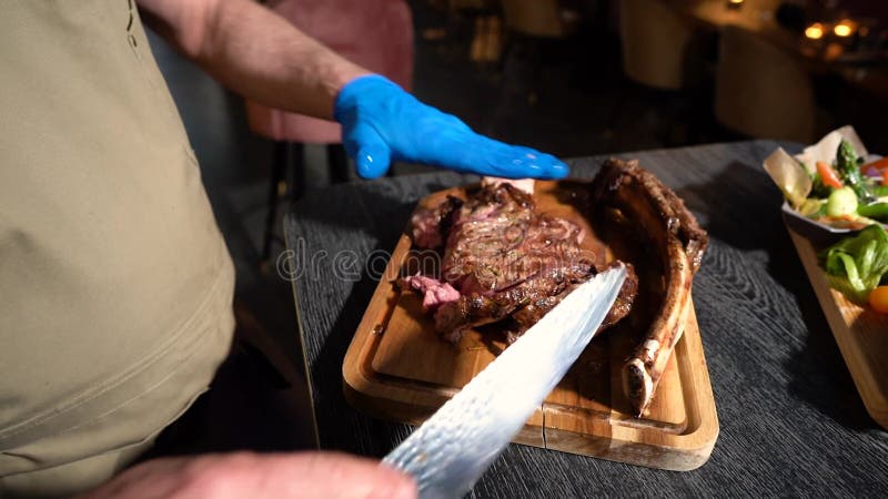 Process of Cutting the Steak with a Large Kitchen Knife on a Cutting ...