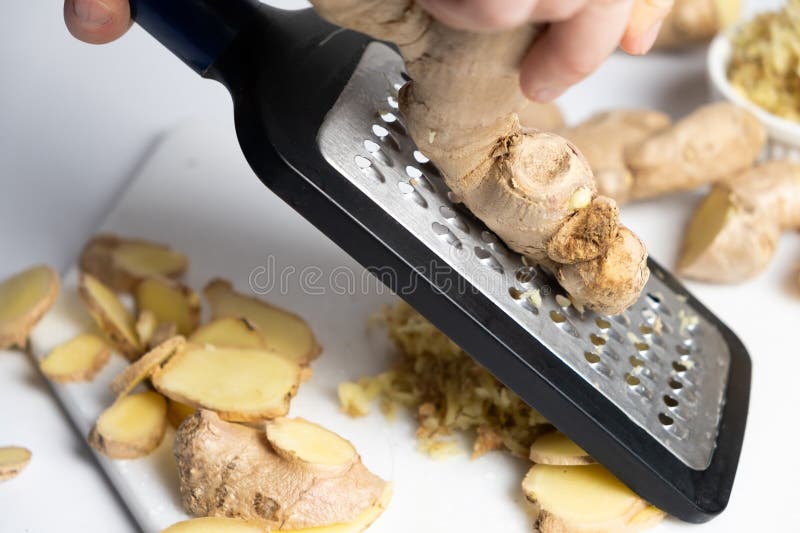 The Process of Grinding Fresh Ginger Root on a Grater Stock Photo ...