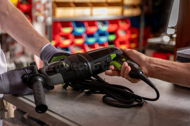 The Process of Handing Over a Power Tool at a Hardware Store is an ...