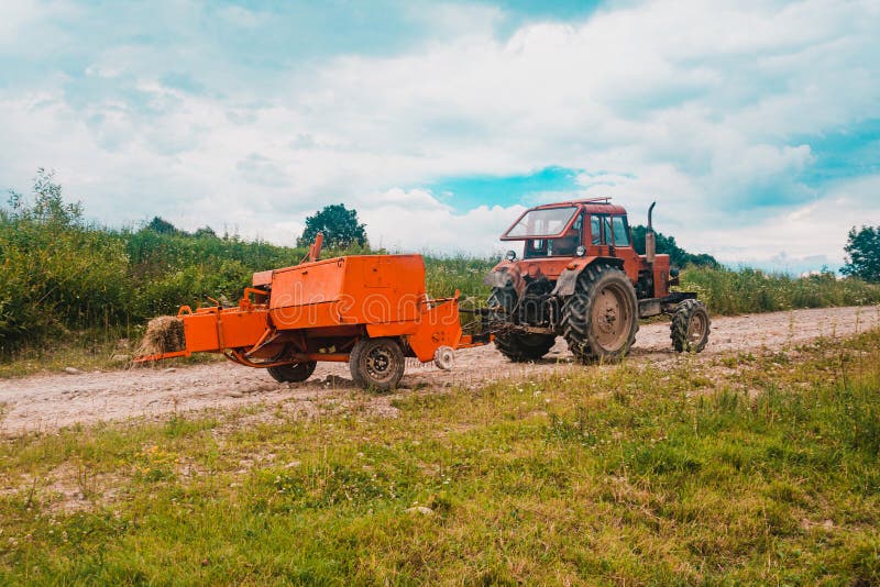 The Process of Harvesting Hay for Cattle, a Tractor Making Bales in the ...