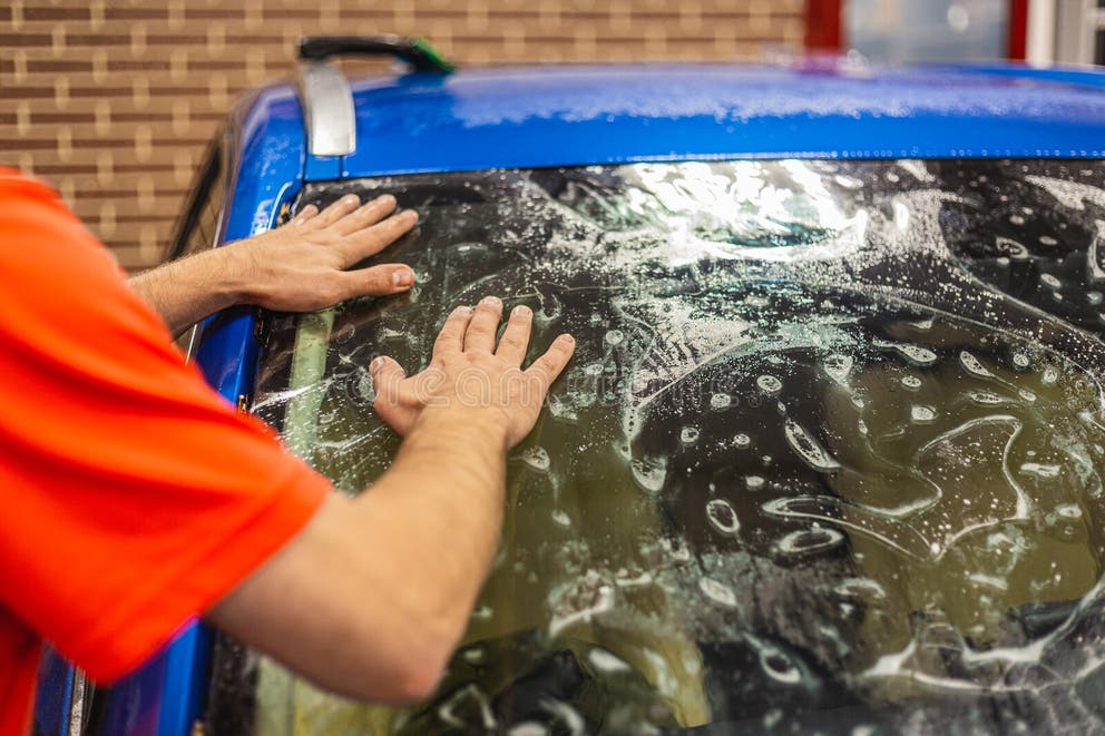 The Process of Installing the PPF on the Windshield of a Car. Stock ...