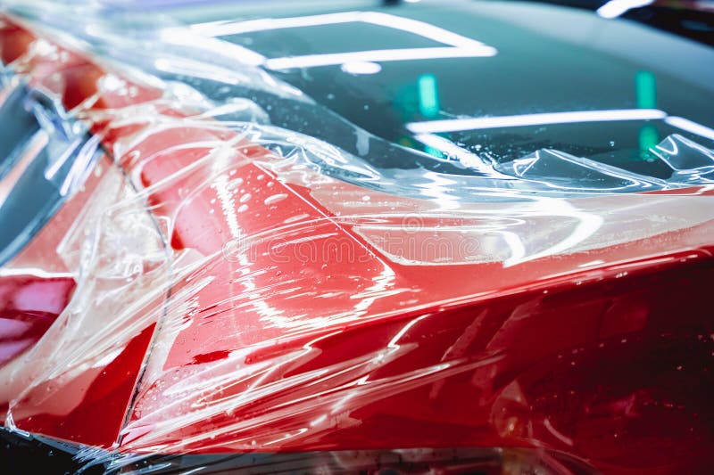 The Process of Installing Protective Film on the New Red Car. Stock ...