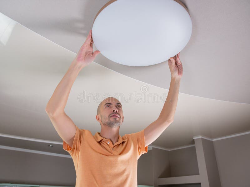 The Process of Installing a Round LED Lamp on the Ceiling in a Room ...