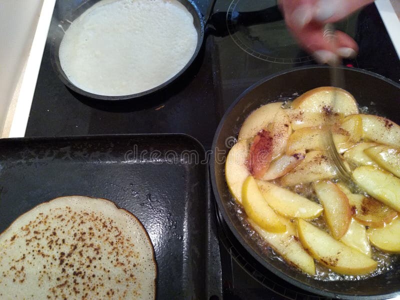 The Process of Making Pancakes with Fried Apples on the Stove Stock ...