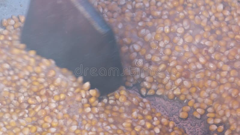 Process of Making Popcorn, Stir Hot Corn Kernels into Popcorn Glaze ...