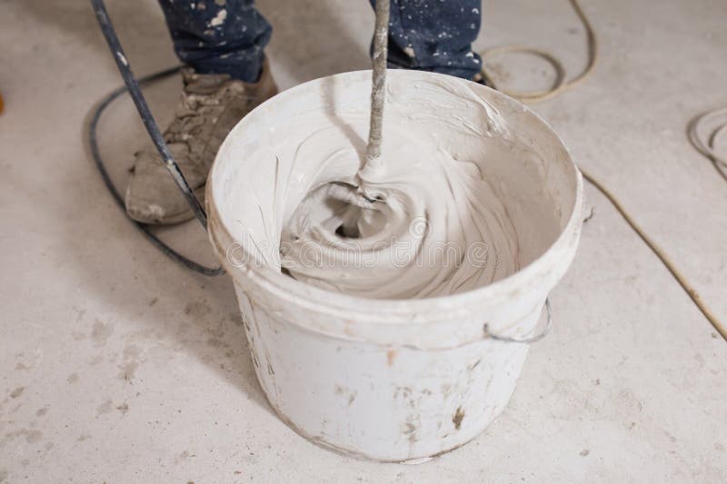 The Process of Mixing the Building Mixture in a Bucket Using an ...