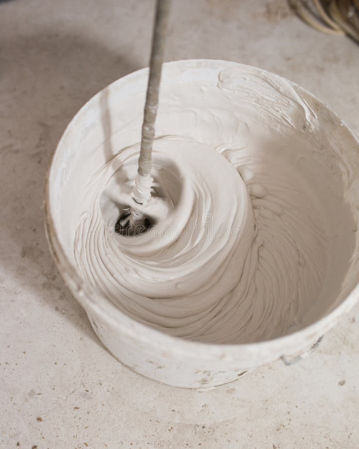 The Process of Mixing the Building Mixture in a Bucket Using an ...