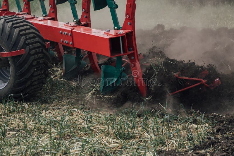 The Process of Plowing the Soil with a Red Plow while Moving Stock ...