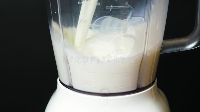 The Process of Pouring Milk into the Bowl of a Blender for Making a ...