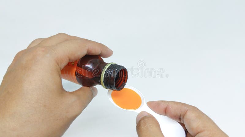The Process of Pouring Orange Medicine into a Measuring Spoon is ...