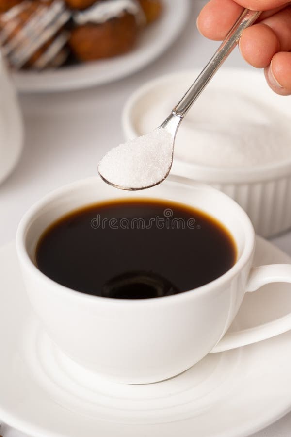 The Process of Pouring White Sugar from a Spoon into a White Cup of ...