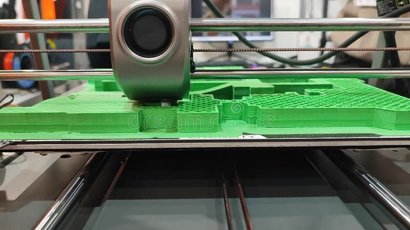 3D Printer Creating a Red Gear Shape on a Flat Surface in a Workshop ...